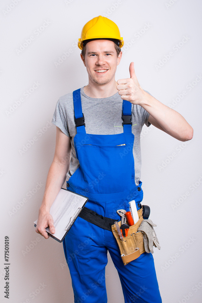 Arbeiter im Blaumann mit Klemmbrett Stock-Foto | Adobe Stock