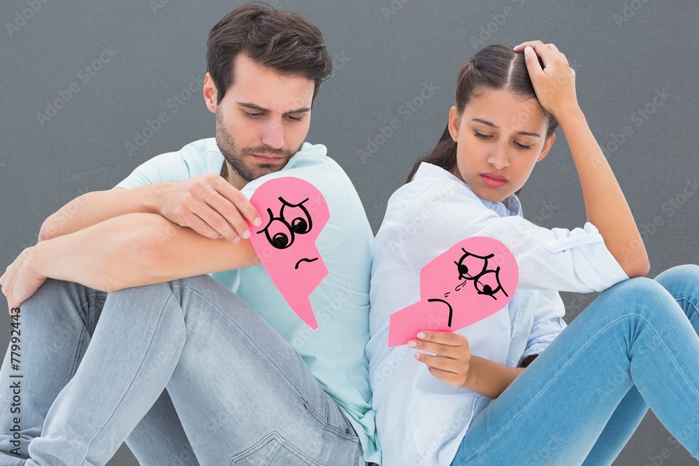 Sad couple sitting holding two halves of broken heart Stock Photo ...