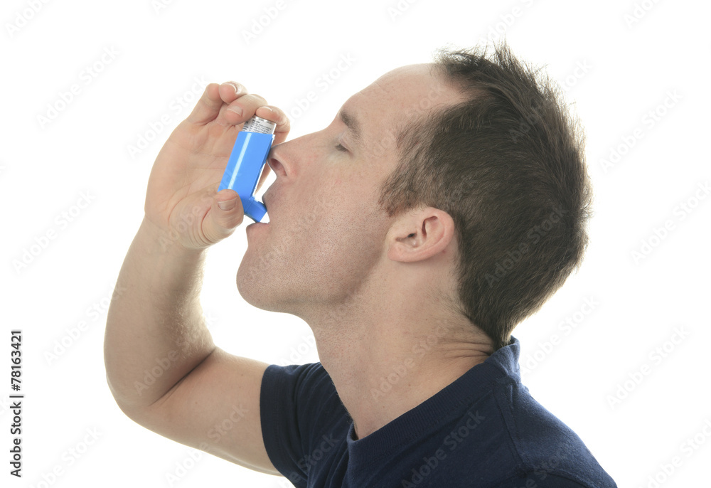 Young man using an asthma inhaler as prevention Stock Photo | Adobe Stock