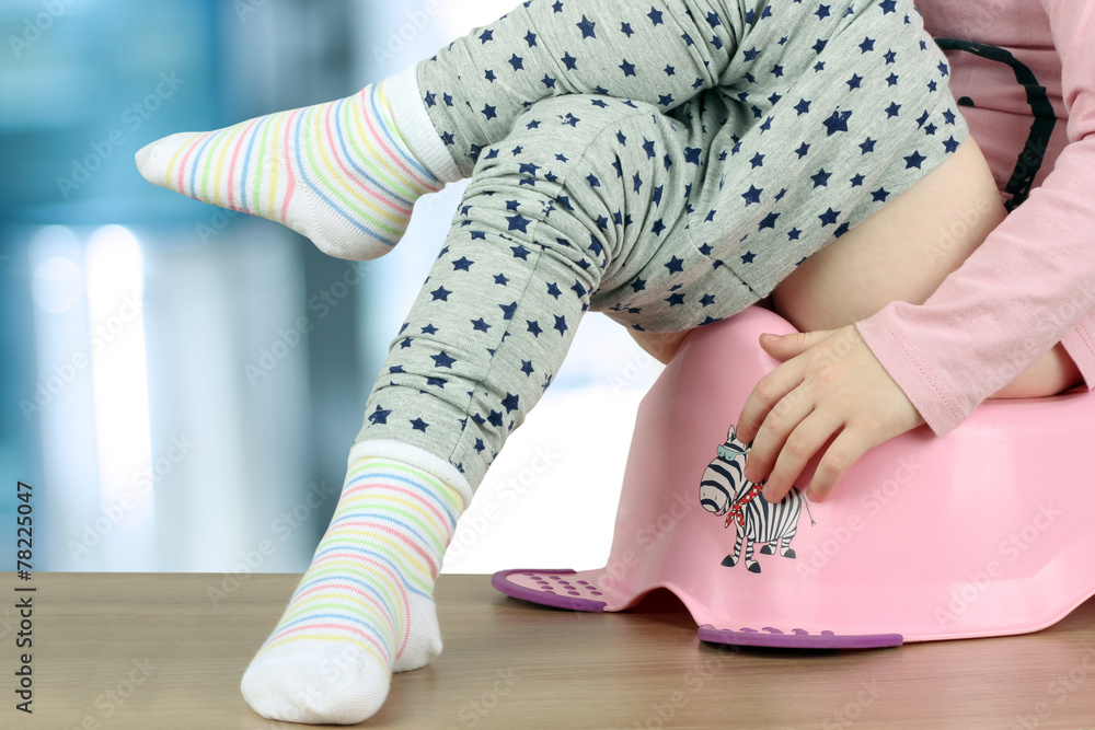 Child sitting on a chamber-pot on a blue background Stock Photo | Adobe ...