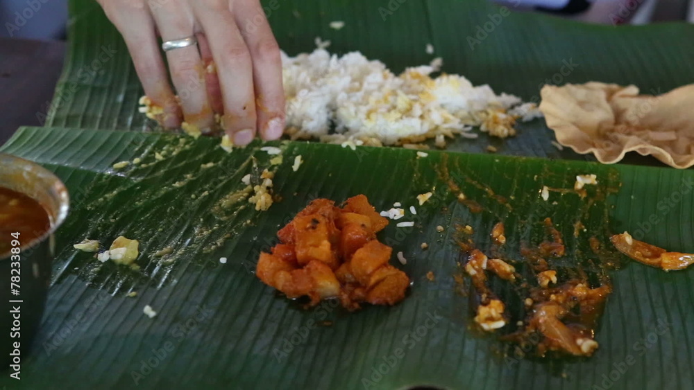 white man eats indian rice with flat cake from banana leaf as th Stock ...