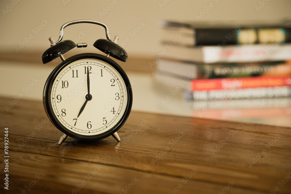 Vintage alarm clock on rustic wood table. Shows 7 o'clock. Pile Stock ...