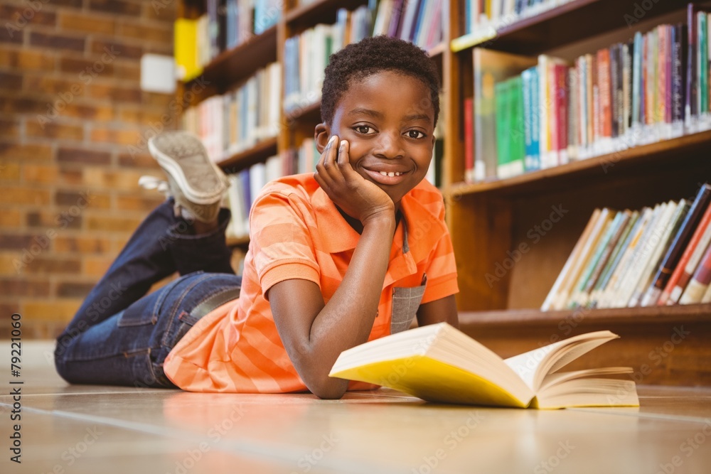 Cute boy reading book in library Stock Photo | Adobe Stock