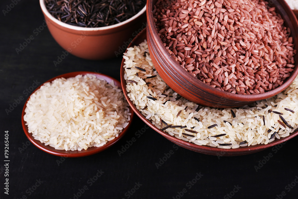 Different kinds of rice in bowls on wooden background Stock Photo ...