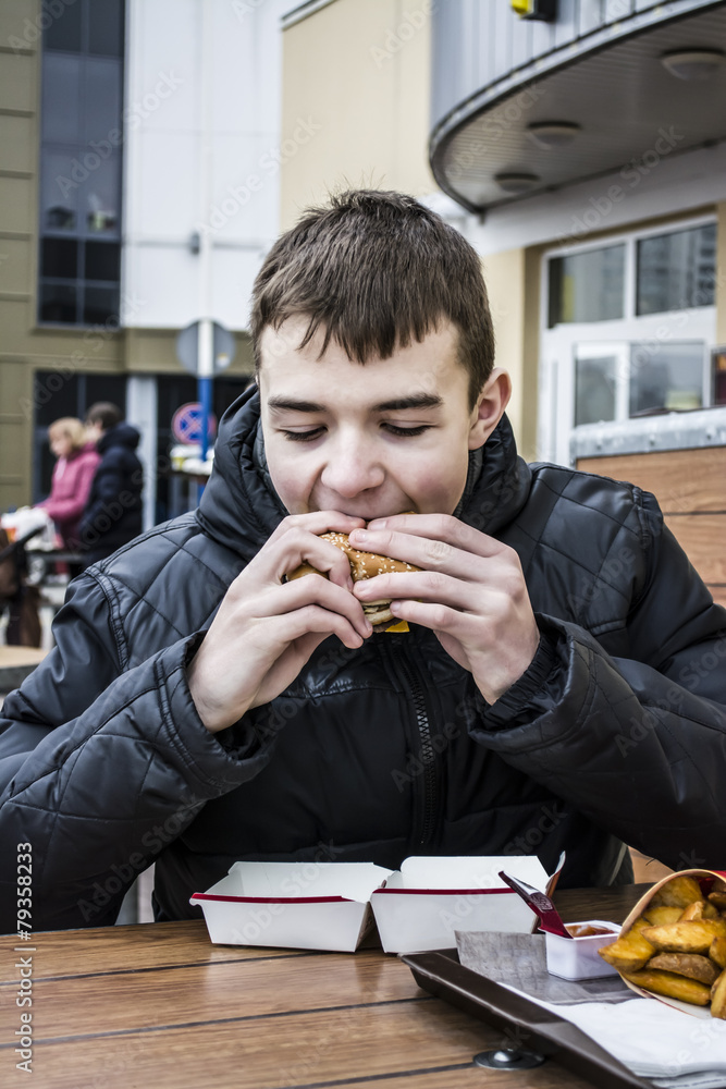 Teen eats fast food Stock Photo | Adobe Stock