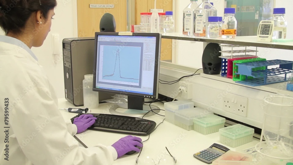 Scientist looking at graphs (dissociation curves from an RT-PCR) on ...