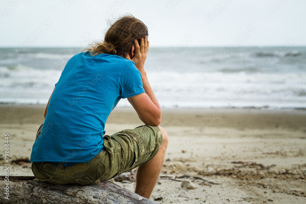 Sad and depressed man sitting alone at the beach Stock Photo | Adobe Stock
