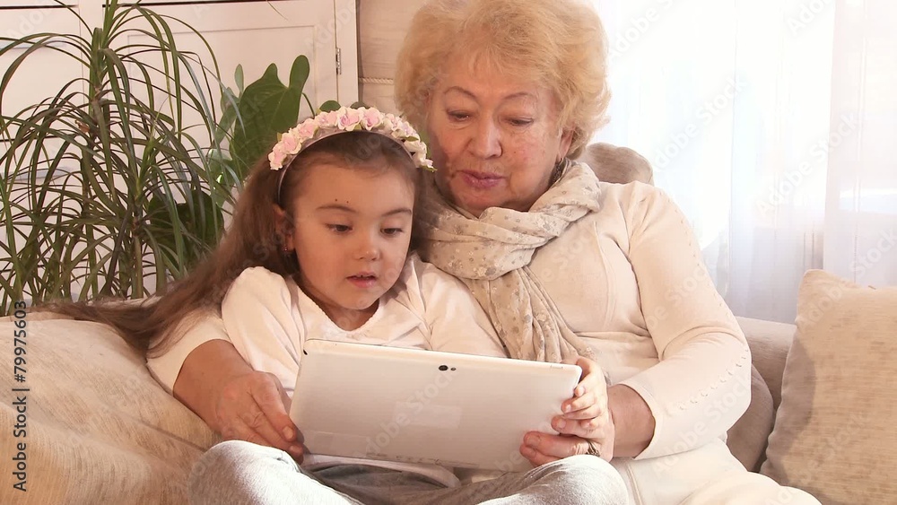 Granddaughter and her grandmother with a digital tablet at home Stock ...