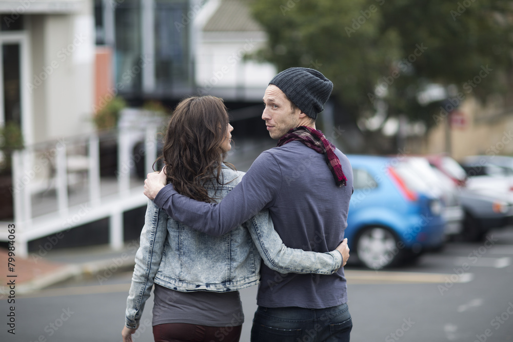 Young couple walking arm in arm on the street Stock-Foto | Adobe Stock