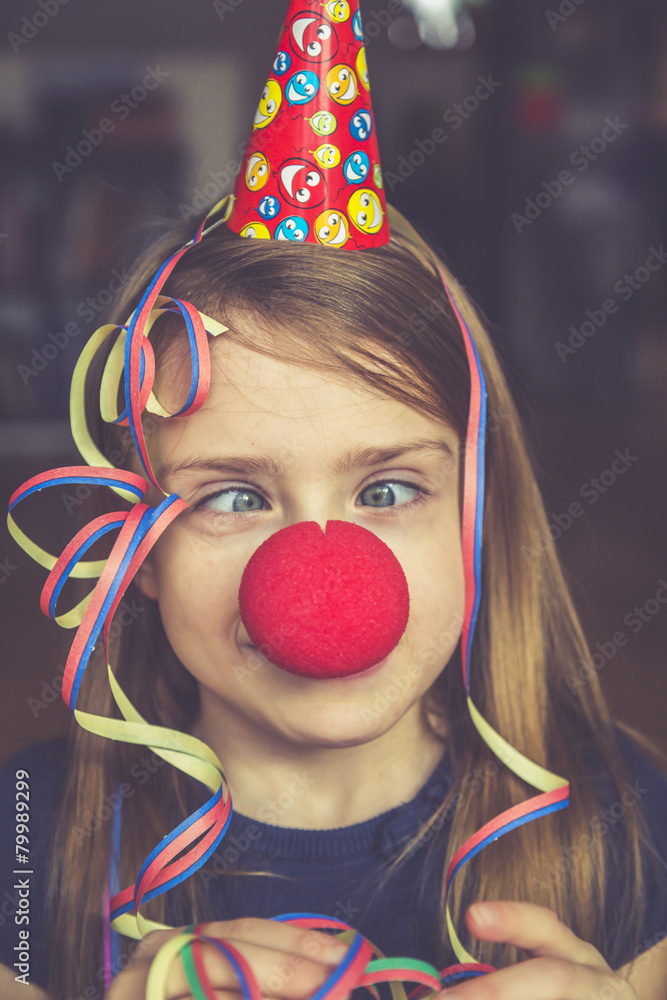 Cross-eyed girl with clown's nose, cap and streamer Stock Photo | Adobe ...
