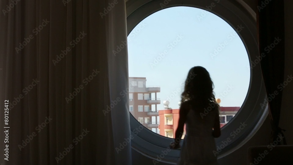 girl closes the curtain on the day of the round window Stock 비디오 ...