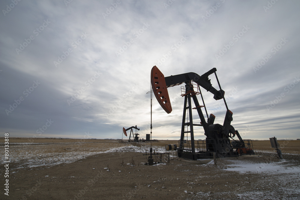An oil pump jack at a drilling site for oil, an oil field in ...