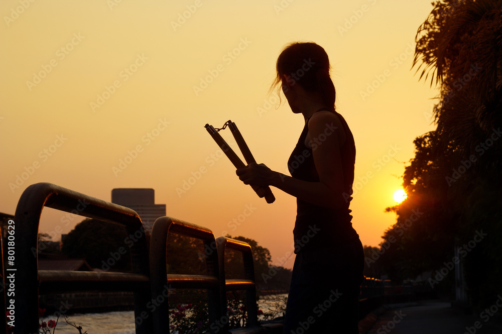 women and nunchaku in hands silhouette in sunset, martial arts Stock ...