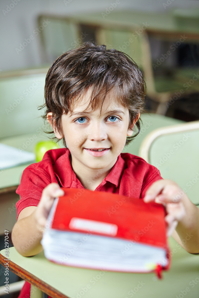 Child in school holding book Stock Photo | Adobe Stock