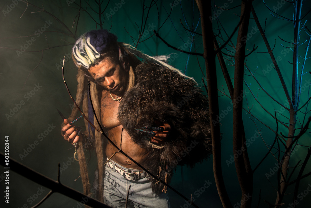 Werewolf with a skin on his skin and long nails among tree branc Stock ...