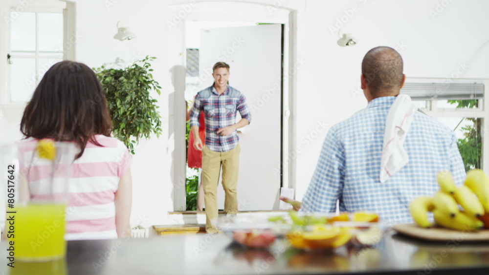 Friendly couple hosting a party at home greet their guests as they ...
