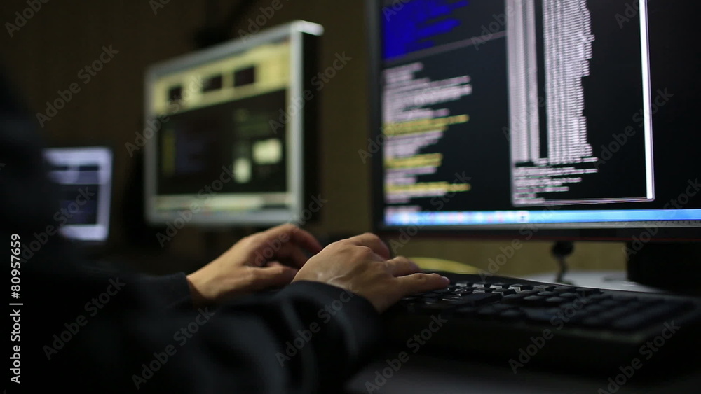 Hacker in hood cracking code using laptop and computers from his Stock ...