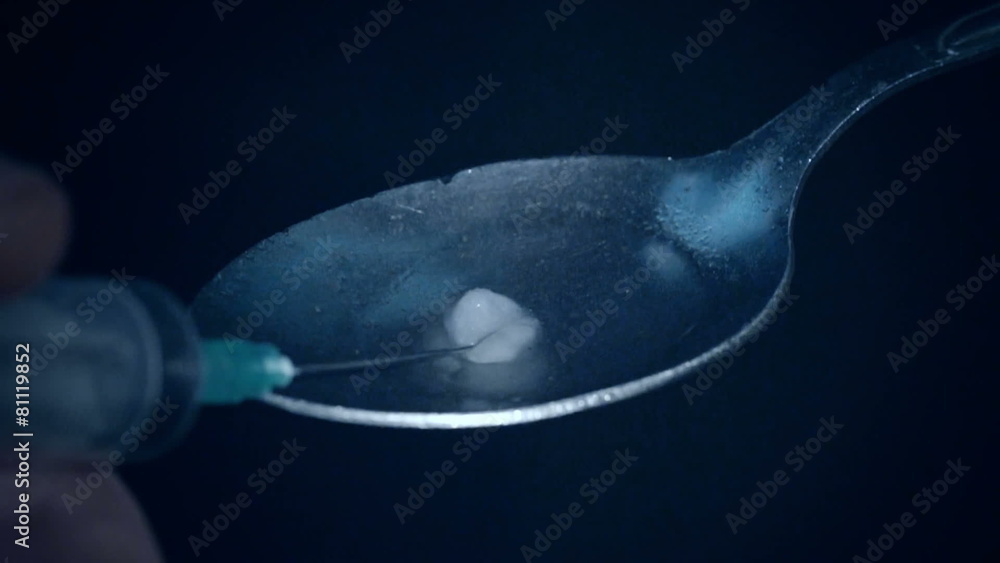 Addict fill a syringe dose of heroin or meth from a spoon Stock Video ...