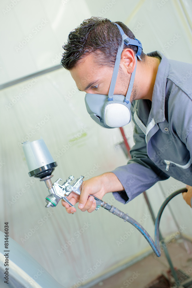 Mechanic spray painting a car Stock Photo | Adobe Stock