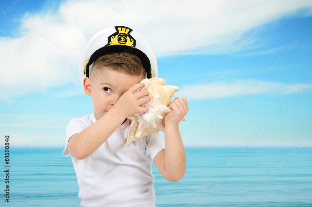 Kleiner Junge mit einer Muschel am Steg Stock-Foto | Adobe Stock