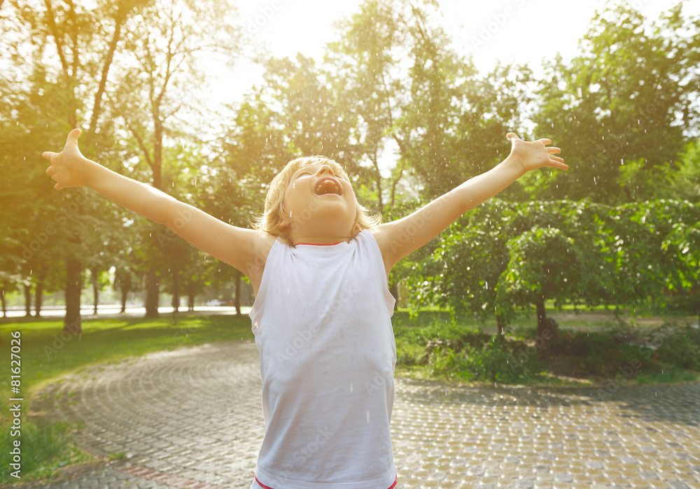 Little boy has fun in the summer rain, toned Stock Photo | Adobe Stock