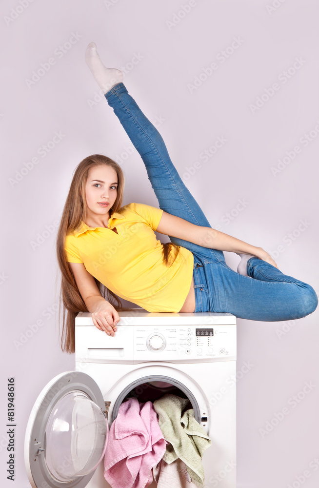 Flexible girl sitting on the washing machine Stock Photo | Adobe Stock