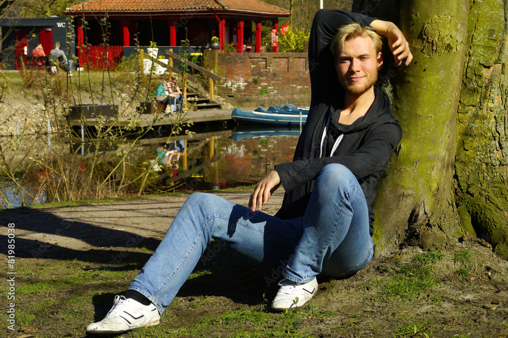 Gut aussehender junger Mann relaxt in der Sonne Stock-Foto | Adobe Stock