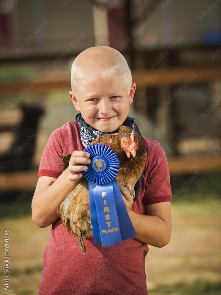 Caucasian boy with prize winning chicken on farm Stock Photo | Adobe Stock