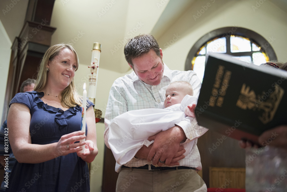 Caucasian parents having baby baptized in church Stock Photo | Adobe Stock