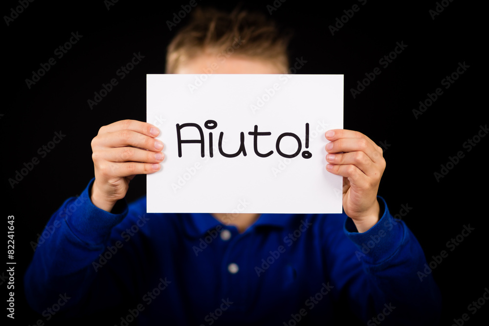Child holding sign with Italian word Aiuto - Help Stock Photo | Adobe Stock