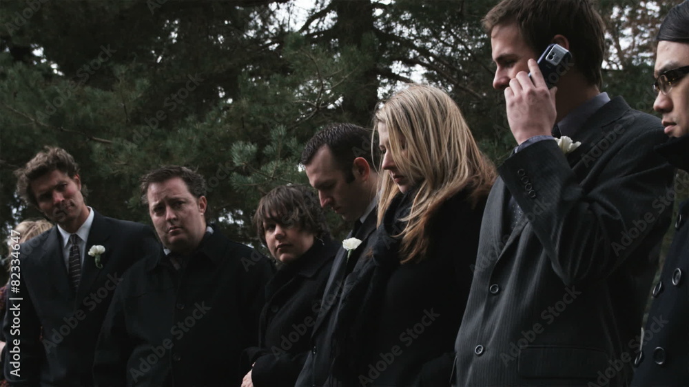 man talking on his cell phone at a funeral Stock Video | Adobe Stock