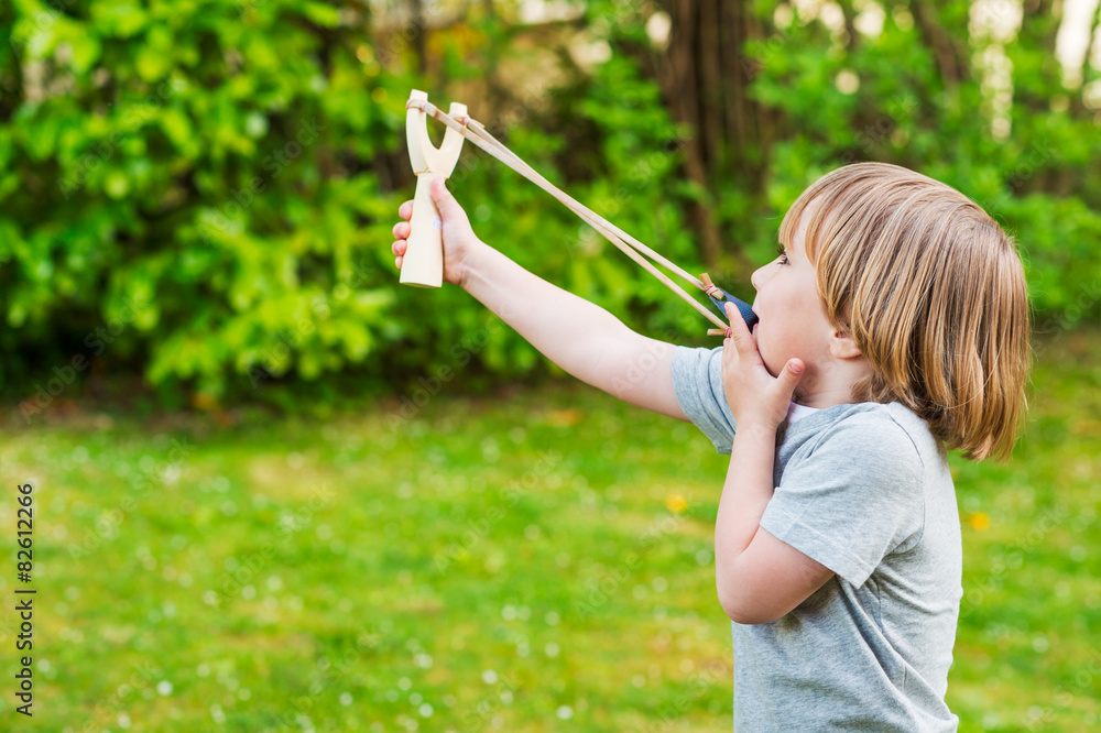Cute little boy playing with slingshot, outdoors Stock Photo | Adobe Stock
