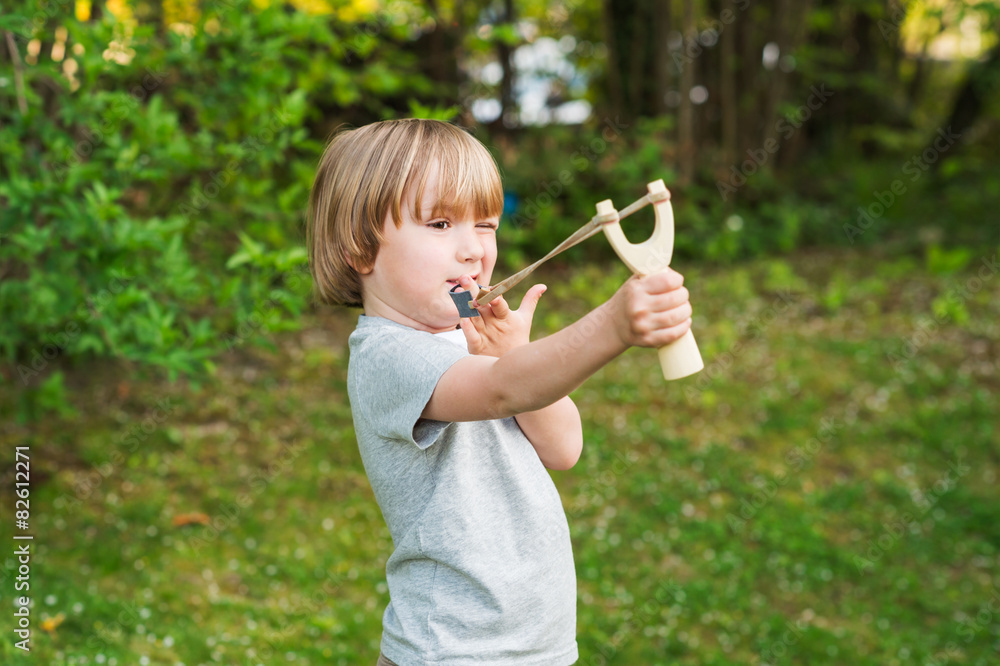 Cute little boy playing with slingshot, outdoors Stock Photo | Adobe Stock