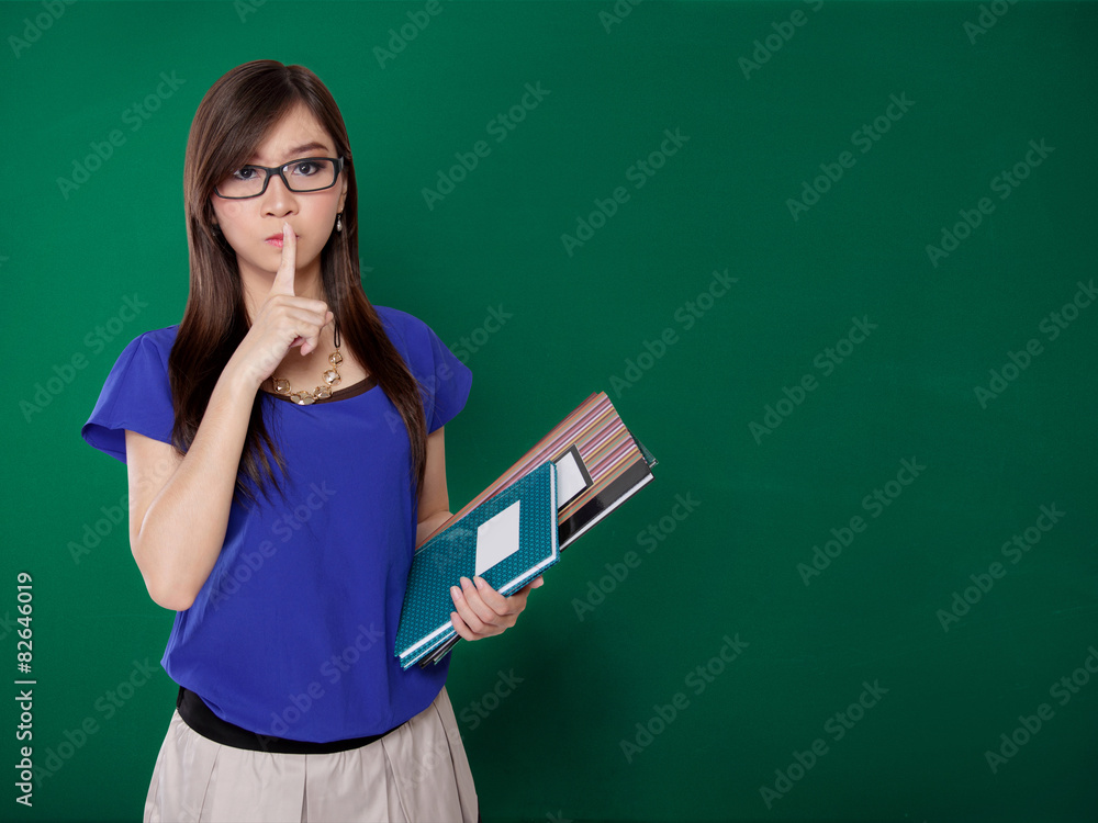 Young teacher asking you to be quiet, on green background Stock Photo ...