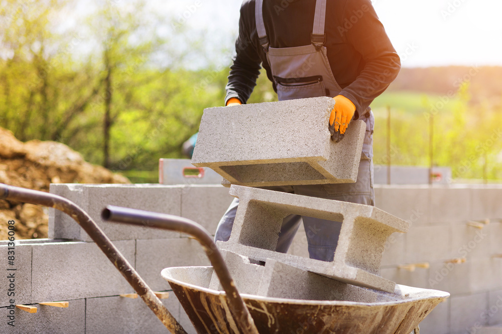 Unrecognizable bricklayer building a wall loading a wheelbarrow Stock ...