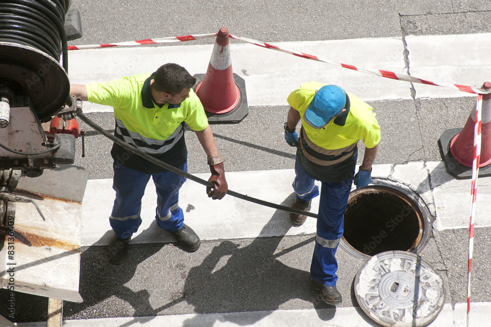 workers moves the manhole cover to check the sewer line Stock Photo ...