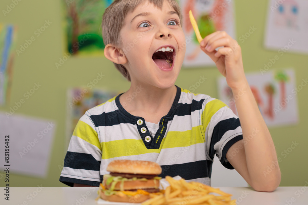 Happy boy eating french fries Stock Photo | Adobe Stock