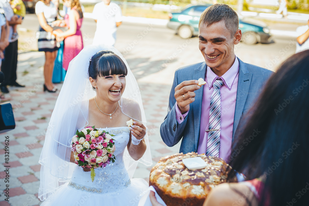 Groom holding slice of traditional wedding round loaf and bride Stock ...