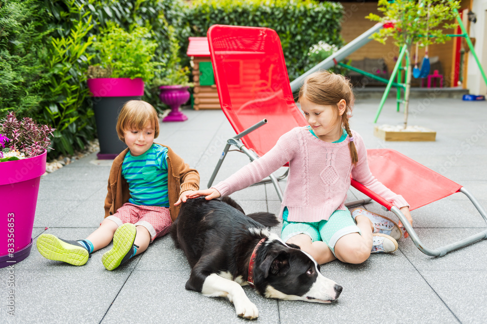 Cute kids playing with a dog on a backyard Stock Photo | Adobe Stock