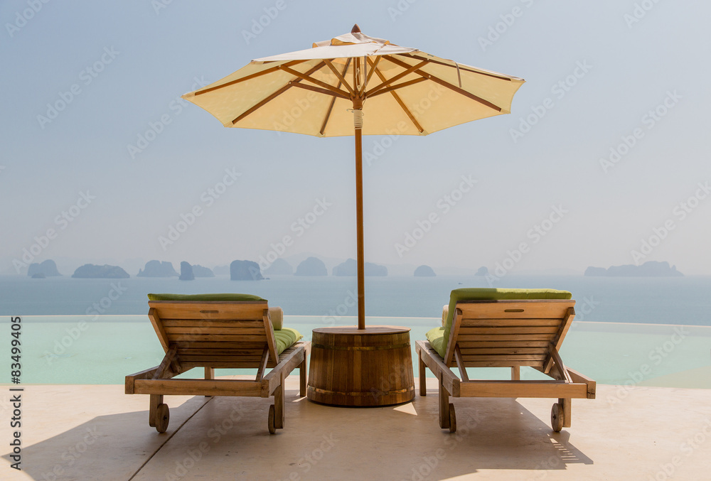 infinity pool with parasol and sun beds at seaside Stock Photo | Adobe ...