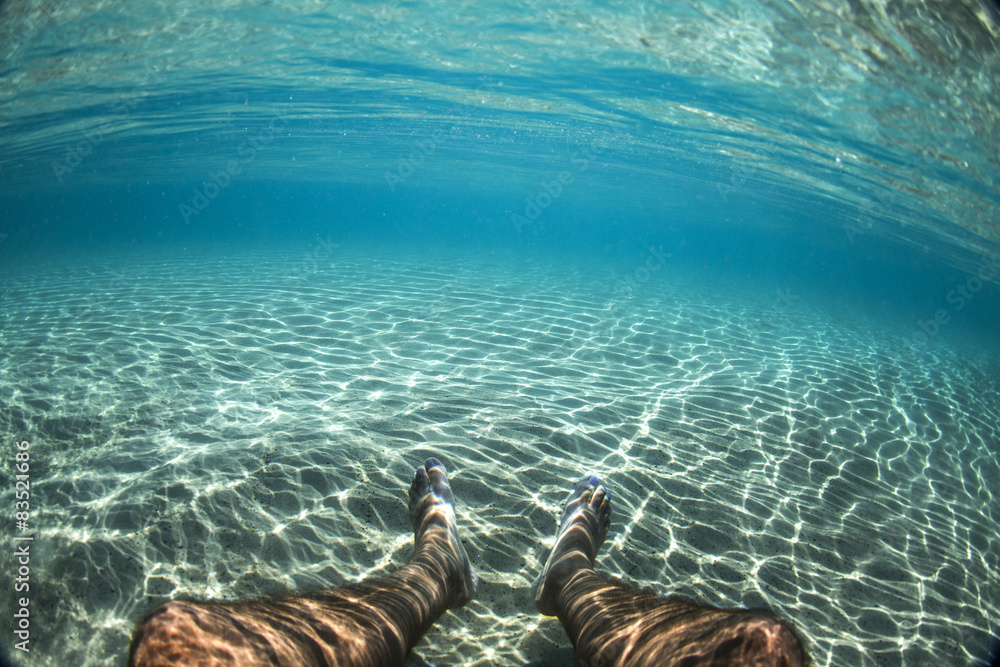 Personal perspective of a Man's outstretched legs underwater sitting on ...