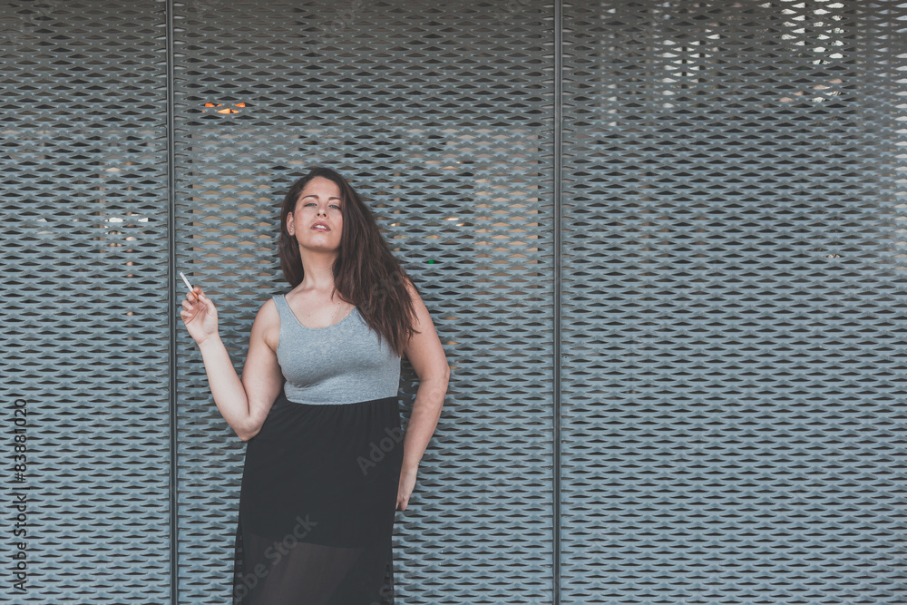Beautiful curvy girl smoking a cigarette in an urban context Stock Photo | Adobe Stock