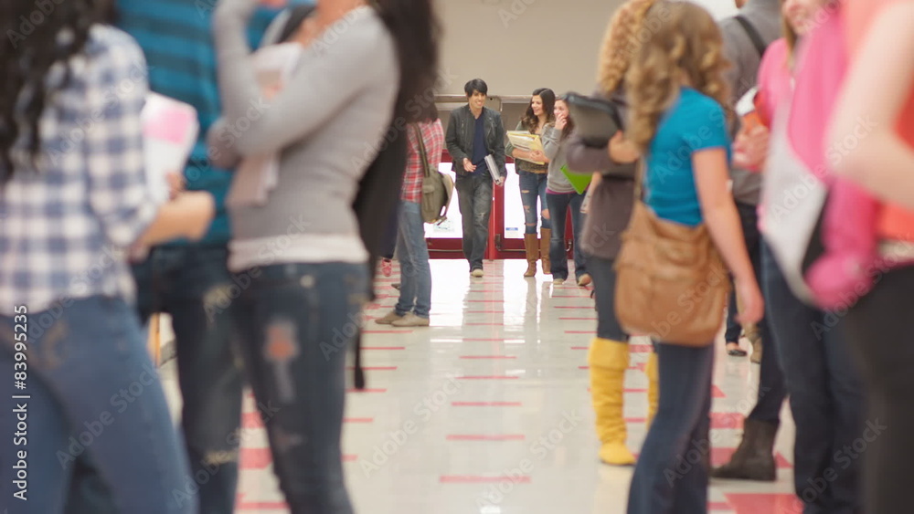 Students run after each other in the hallway full of other students ...
