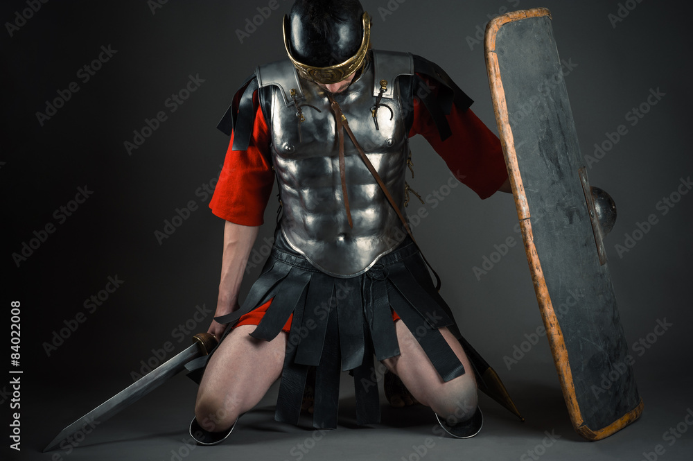 tired soldier kneeling with a shield and a sword in hands Stock Photo ...