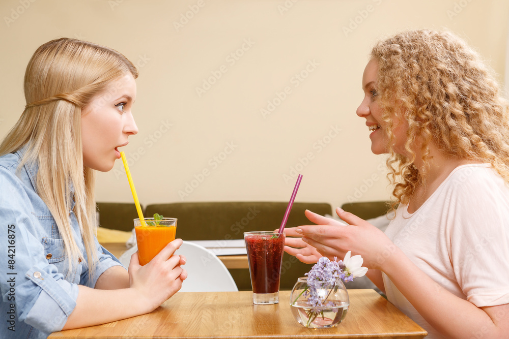 Two girls having conversation in cafe Stock Photo | Adobe Stock