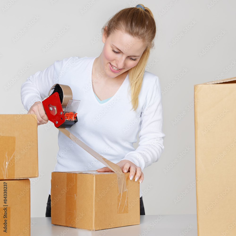 Woman wraps up a packet for delivery Stock-Foto | Adobe Stock