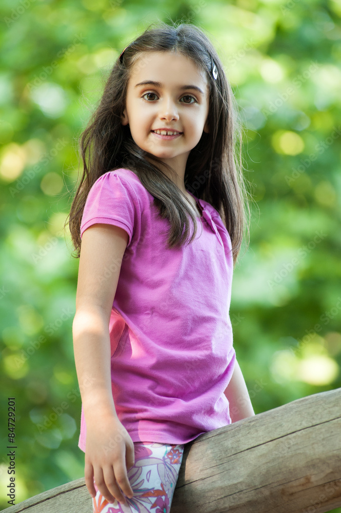 Cute little girl straddling a wooden pole Stock Photo | Adobe Stock