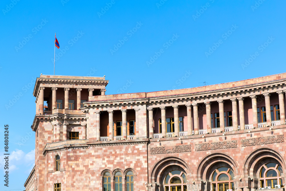 Monumental building of red tuff with the flag of the Republic of ...