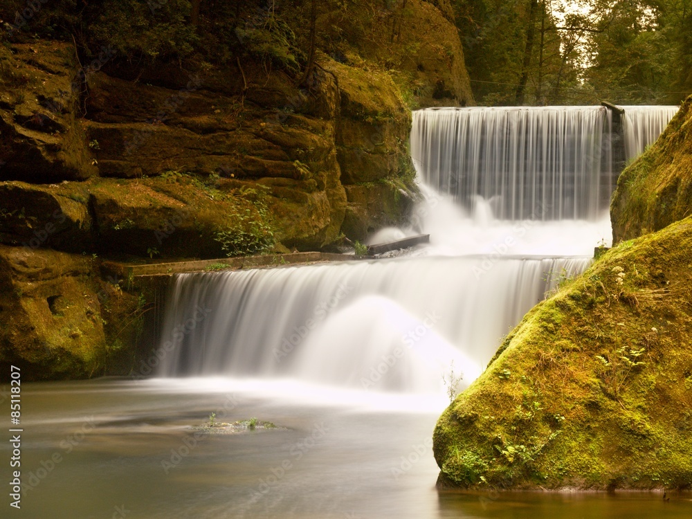 Stony weir on small mountain river. Stream is flowing over blocks and ...
