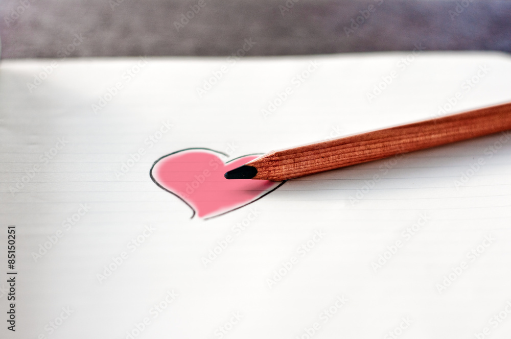 Pencil lying on a notepad with a drawing of a pink heart Stock Photo ...